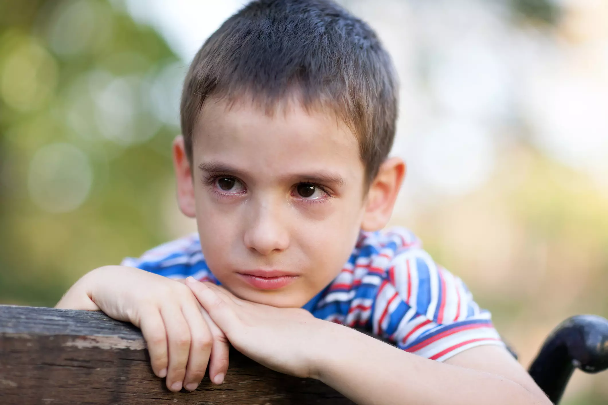 En ung ADHD-pojke med ångest som gråter utomhus