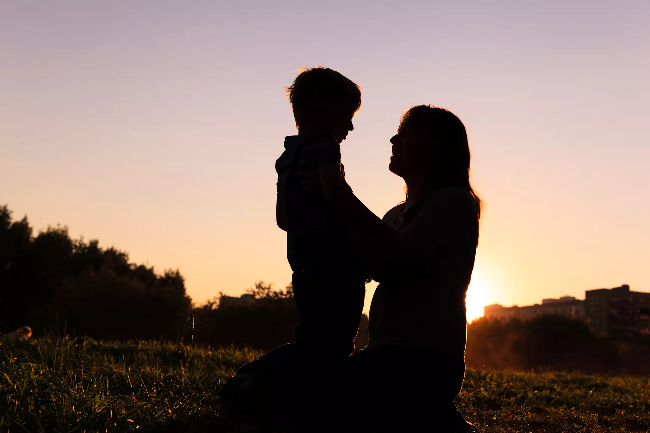 日落时快乐的母亲和多动症小儿子