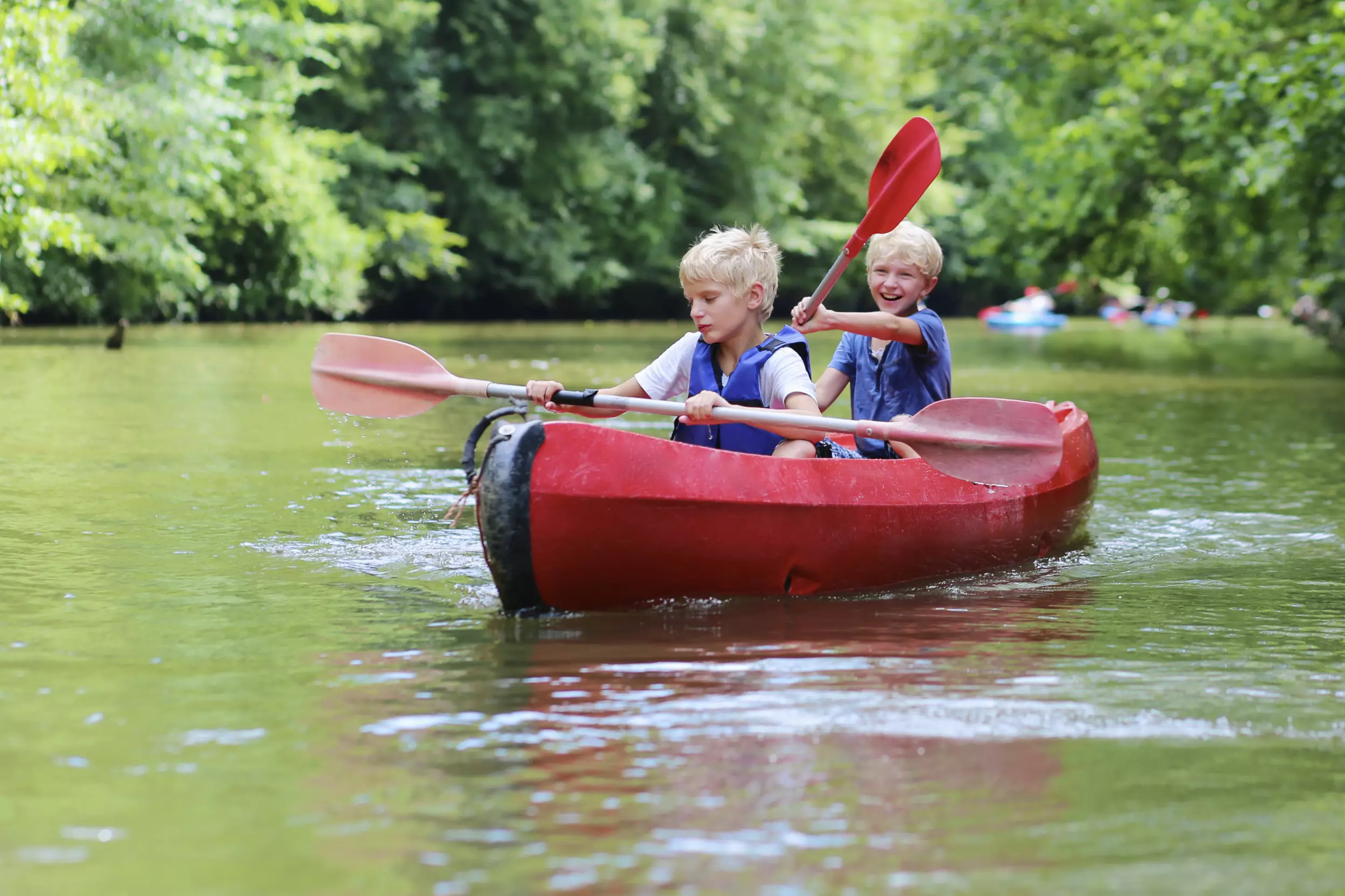 Hai cậu bé ADHD chèo thuyền kayak trên hồ tại trại hè