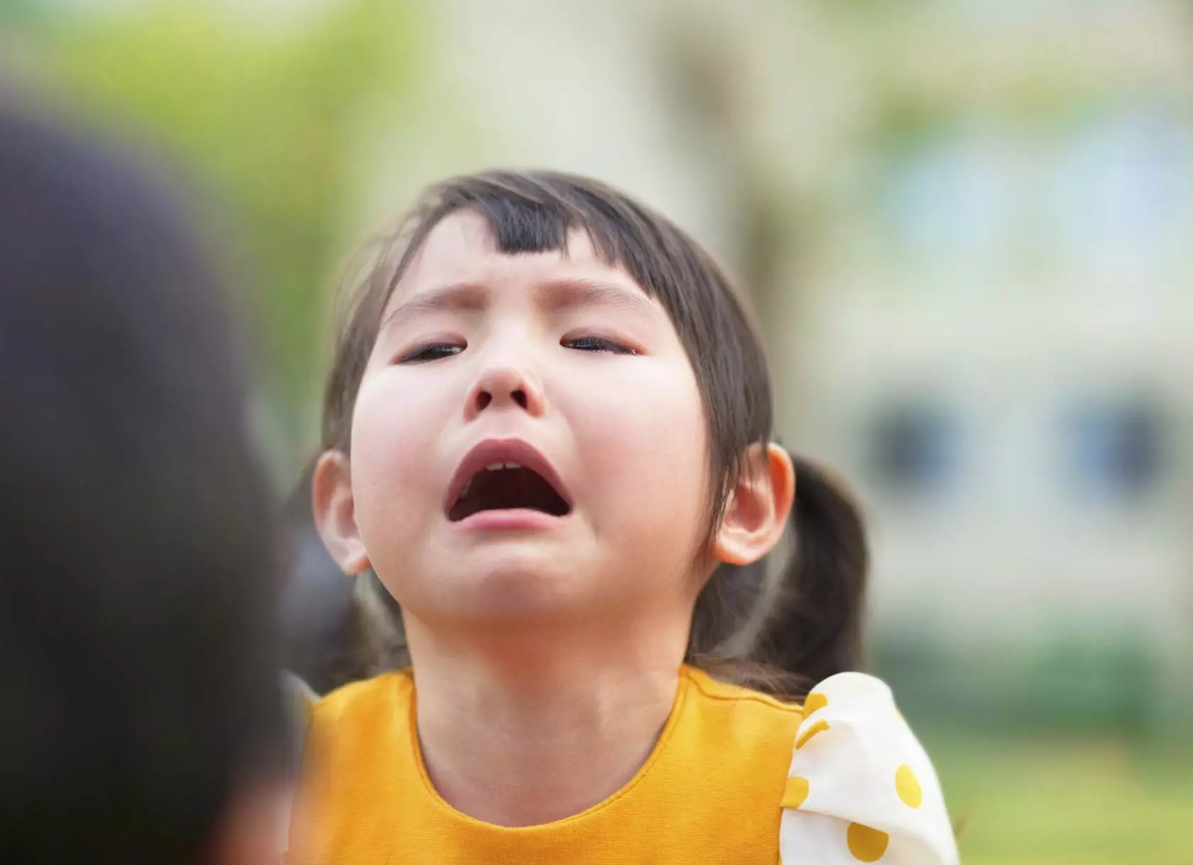 یک دختر جوان ADHD در حال گریه پس از اینکه والدینش عواقب رفتار بد را اعلام کردند