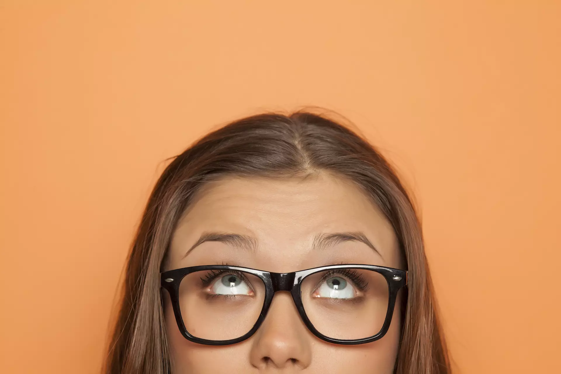 половин портрет на младо момиче с очила, гледащи нагоре