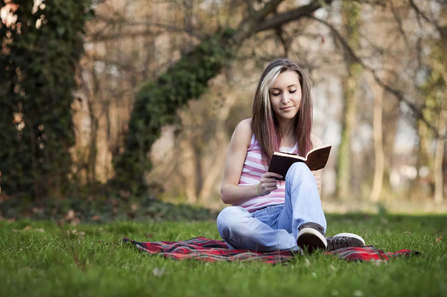 एक विकलांग लड़की एक किताब पढ़ती है।