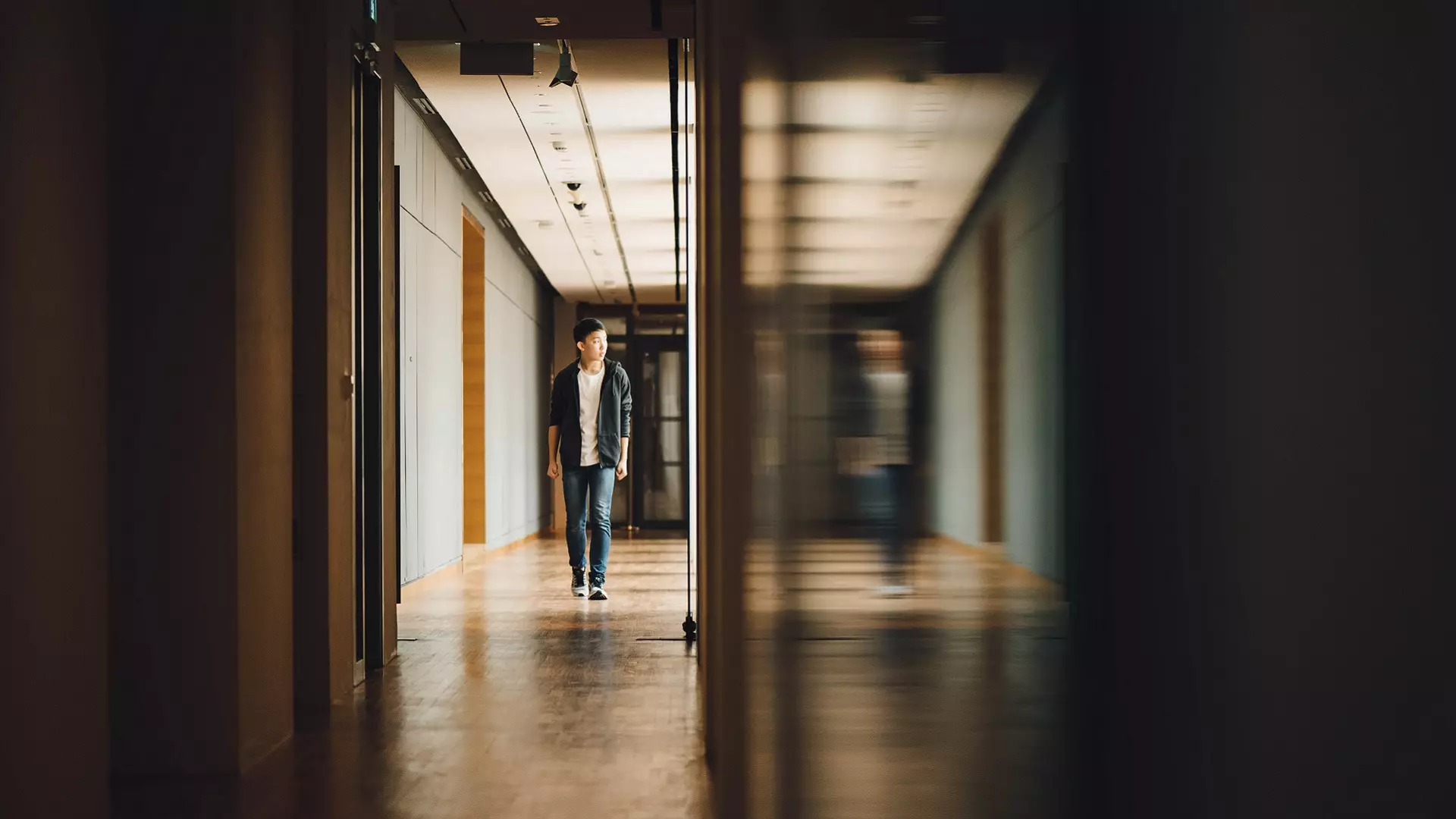 Seorang remaja ADHD dengan masalah motivasi berjalan di lorong sekolah