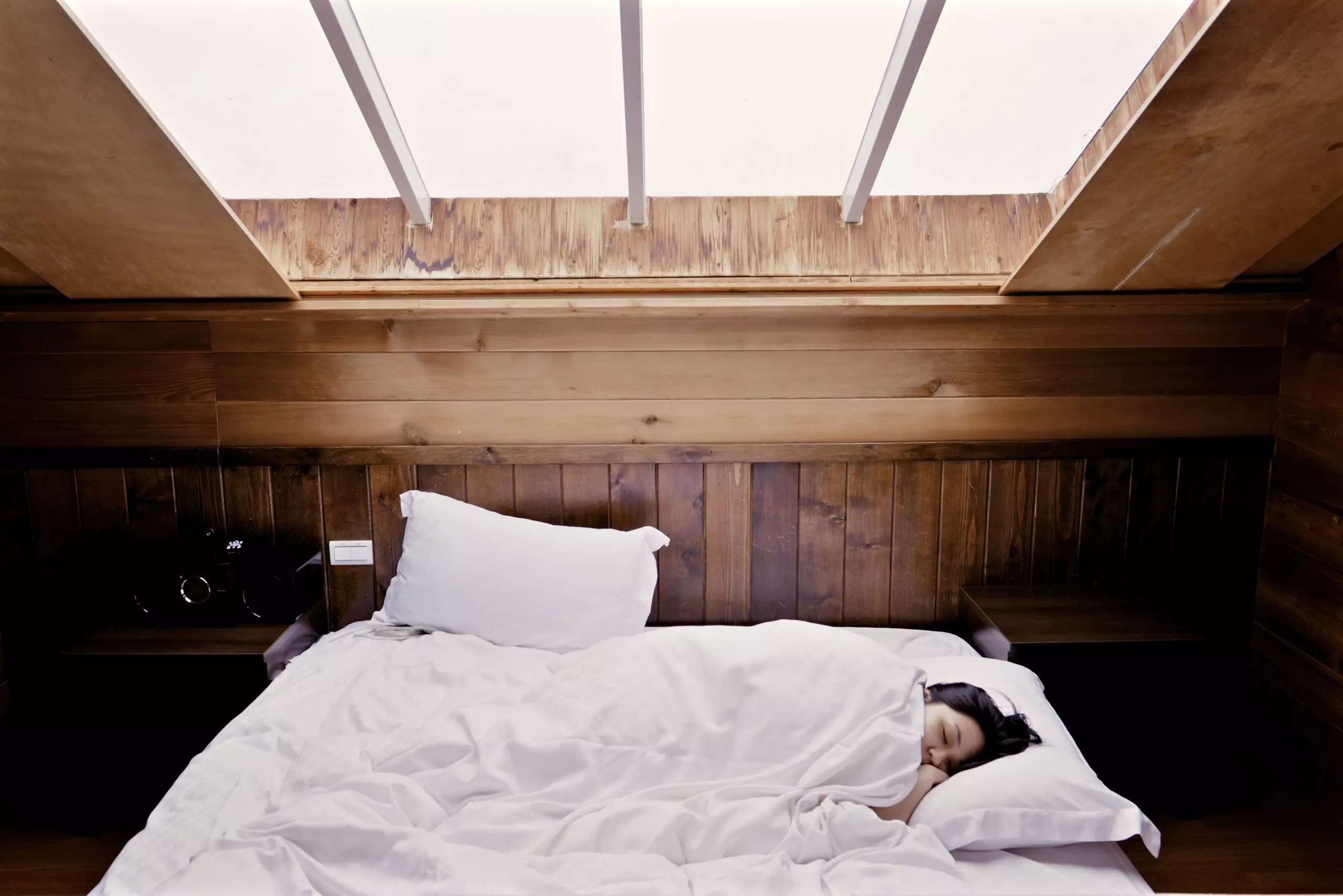 Een vrouw slaapt tot ver in de dag nadat ze de avond ervoor symptomen van slapeloosheid heeft ervaren.